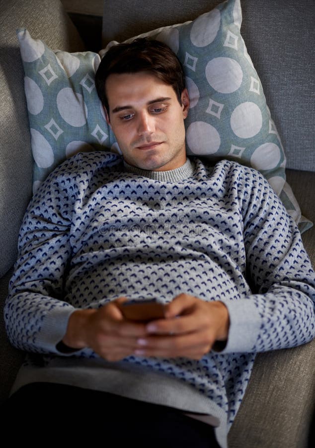 Texting His Girlfriend a Bedtime Story. a Handsome Young Man Looking at ... Texting His Girlfriend a Bedtime Story. a Handsome Young Man Looking at ...