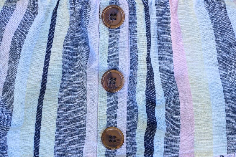 Three Brown Plastic Buttons on Colored Striped Fabric Clothes Stock ...