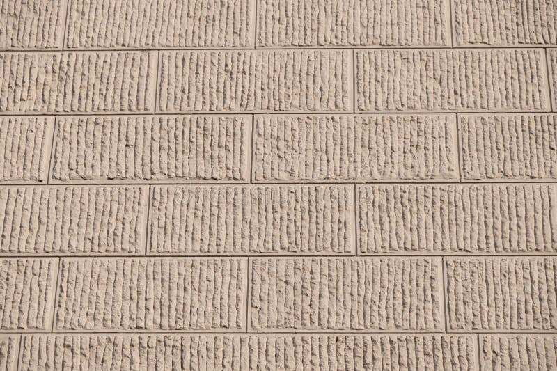 Textured Beige Stone Wall with Vertical Ridges, Arranged in a ...