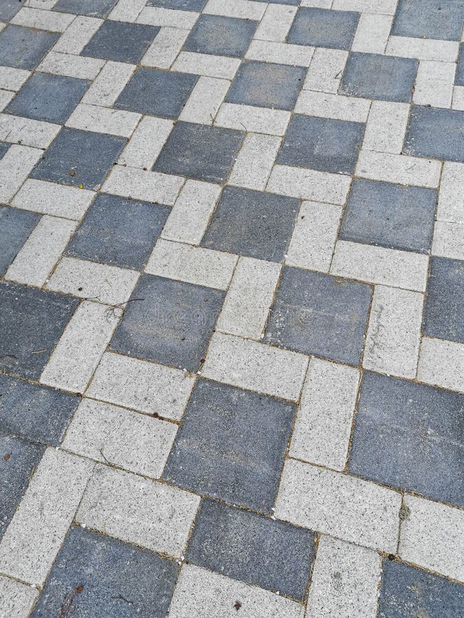 Textured Pavement with Alternating Gray and White Tiles Creating a ...