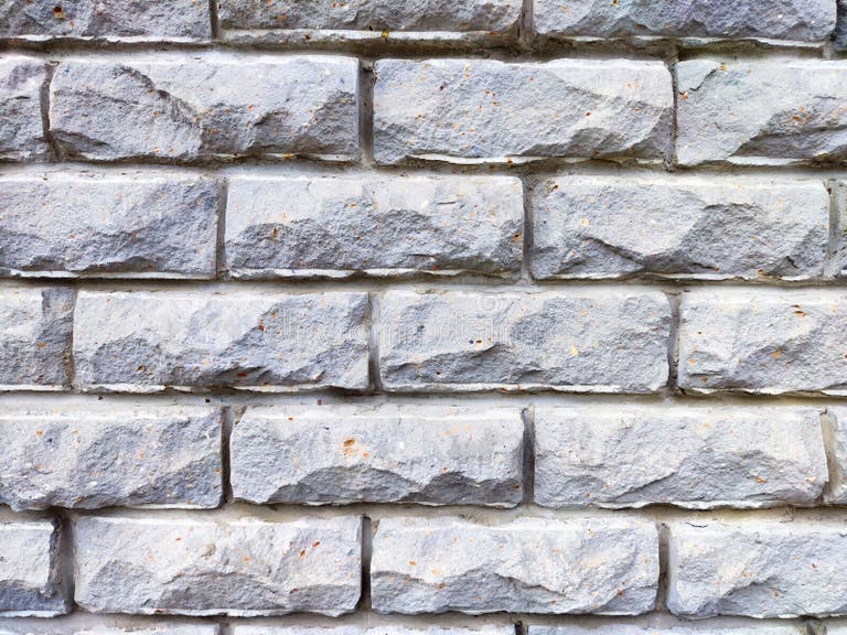 A Textured Stone Wall Displays a Uniform Gray Pattern, Creating a Solid ...