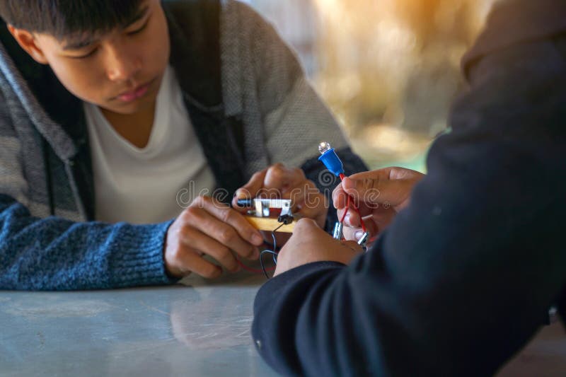 Thai Boy Performs an Outdoor Science Experiment on Connecting a Simple ...