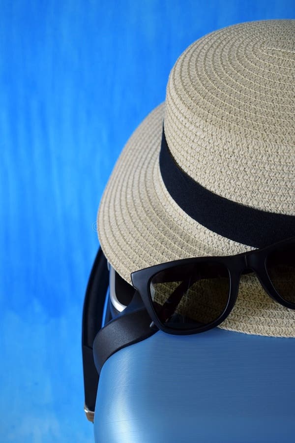 A Thatch Hat and Sunglasses on a Blue Suitcase Stock Photo - Image of ...