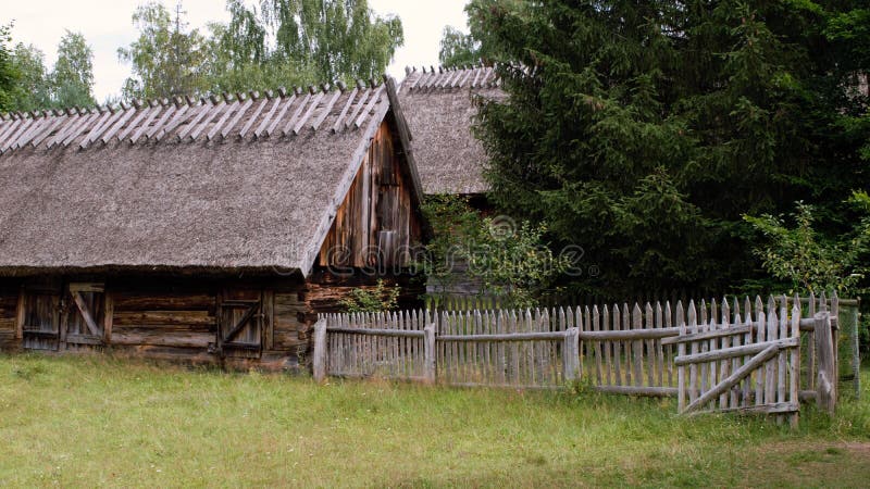 A Thatched Country Cottage with a Fence, Lawn and Trees Stock Photo ...