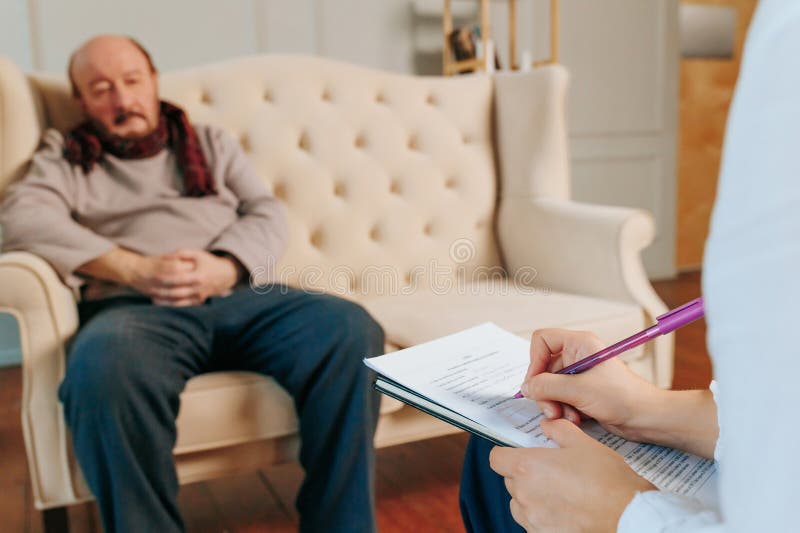 Therapist Takes Notes while Patient Sits Quietly on a Comfortable Couch ...