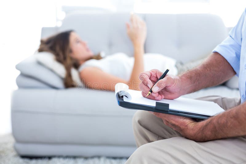Therapist Writing on Notepad with Female Patient Stock Photo - Image of ...