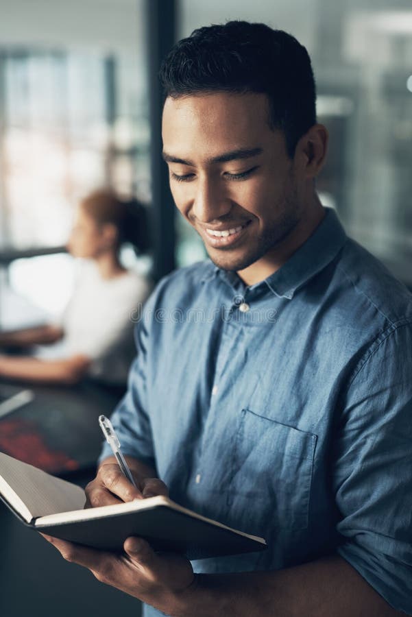 There Aint No Looking Back. a Happy Young Man Making Notes in a Book in ...