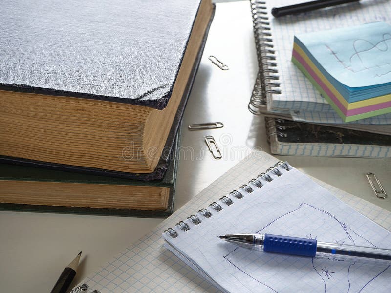 There are Books, Notebooks, a Notepad with a Pen on the Table. There is ...