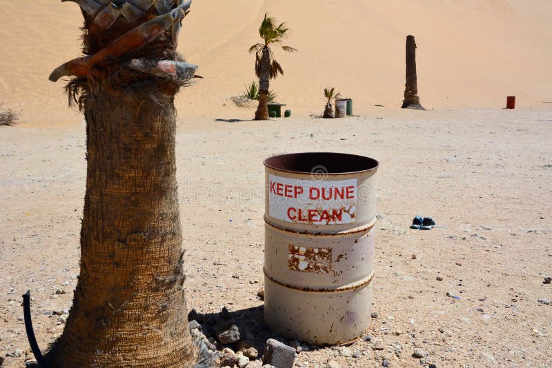 There is a Garbage Container with a Warning Sign Next To a Palm Tree on ...