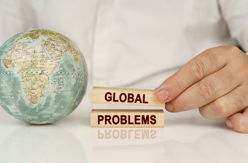 There is a Globe on a White Reflective Surface, in the Hands of Wooden ...