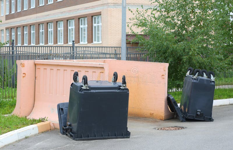 There is an Inverted Black Plastic Containers by the Pink Wall of the ...