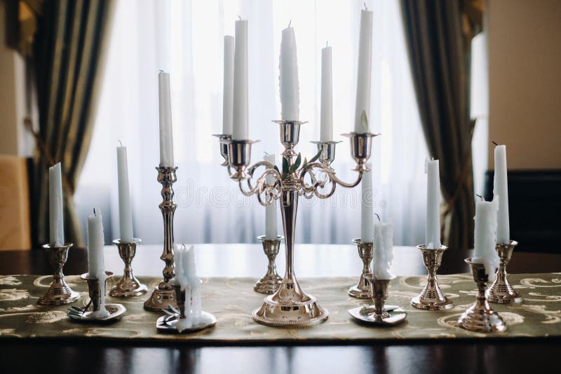 There are a Lot of Candles in Candlesticks Standing on the Table ...