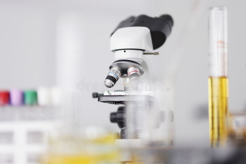 There is Microscope and Test Tube with Yellow Liquid in Laboratory ...