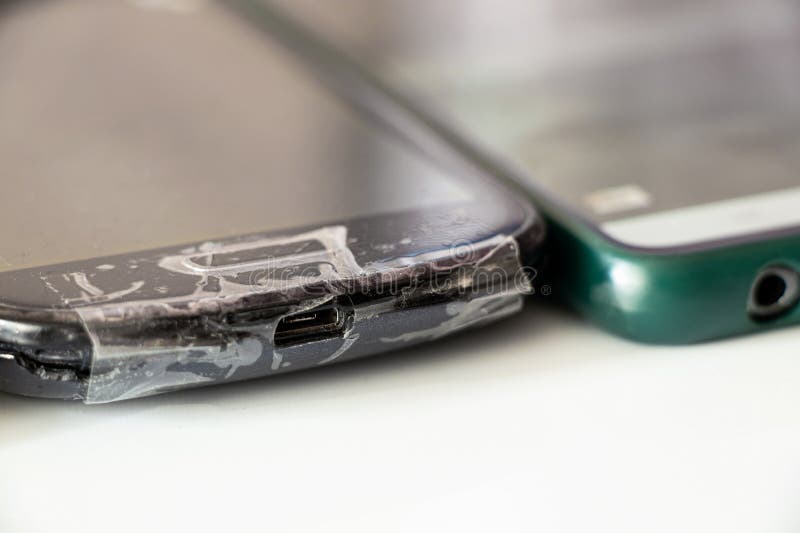 There is an Old Touch Mobile Phone Covered with Tape on the Table ...