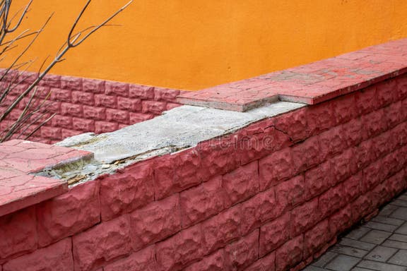 There is a Pink Brick Wall that Features a White Ledge on Its Side ...