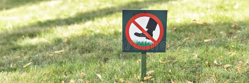 There is a Sign on the Lawn with a Sign Forbidding Walking on the Grass ...