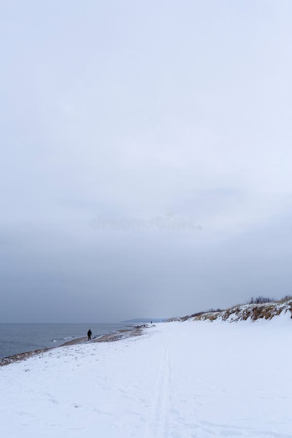 There is Snow on the Seashore, People are Walking in the Distance Stock ...