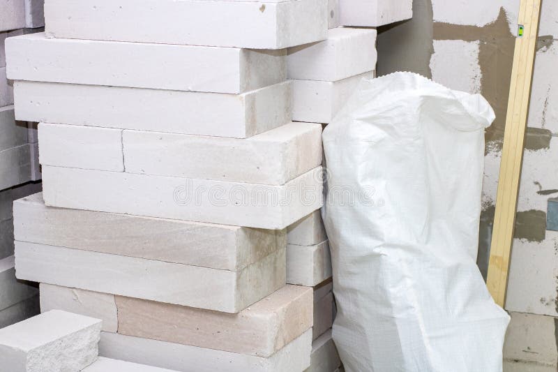 There is a Stack of White Bricks Located Next To a White Bag Stock ...