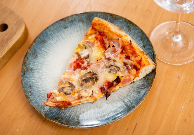 There is Triangular Slice of Fresh Pizza with Bacon and Mushrooms on ...