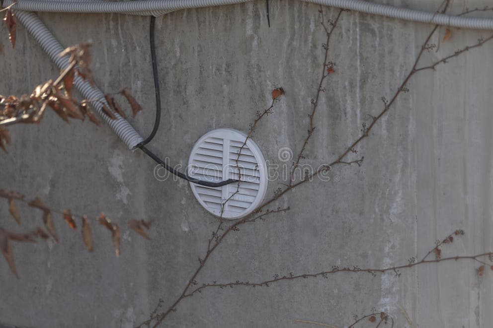 A White Vent Installed on a Concrete Wall with a Wire Protruding from ...