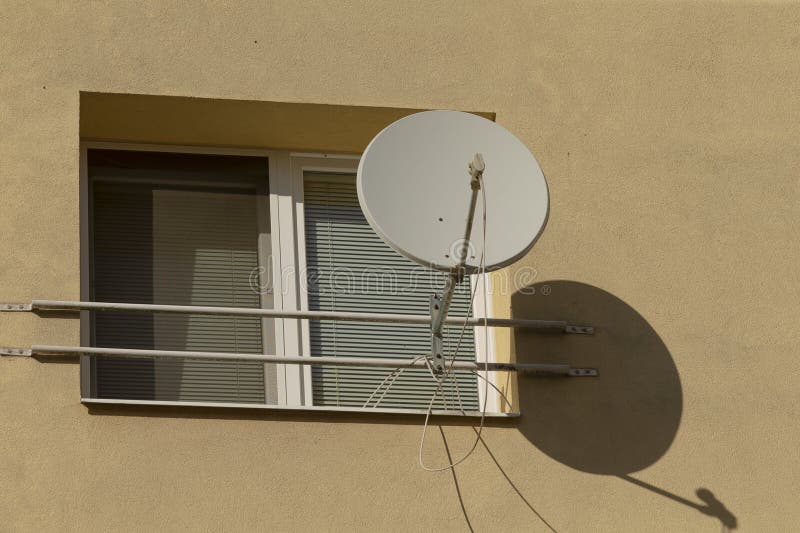 A Window that Has a Satellite Dish Mounted on Its Exterior Side Stock ...
