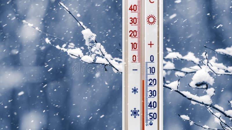 The Thermometer on a Background of a Snow-covered Tree Branch Shows ...