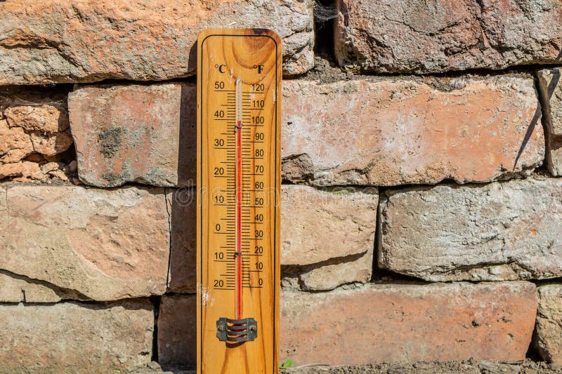 Thermometer Displaying High Summer Temperature on a Brick Wall Backgrou ...