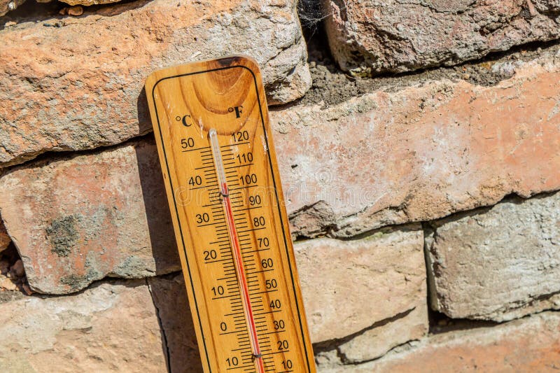 Thermometer Displaying High Summer Temperature on a Brick Wall Backgrou ...