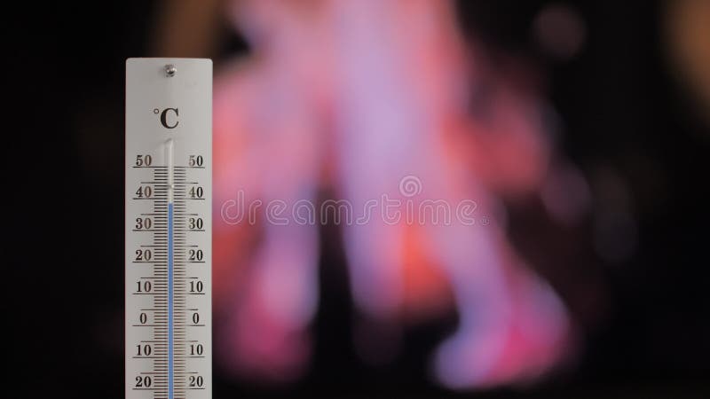 Thermometer with a Fire in the Background Shows Increasing Temperature ...