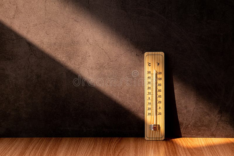 A Thermometer on a Wooden Table with Light and Shadow on Old Gray ...
