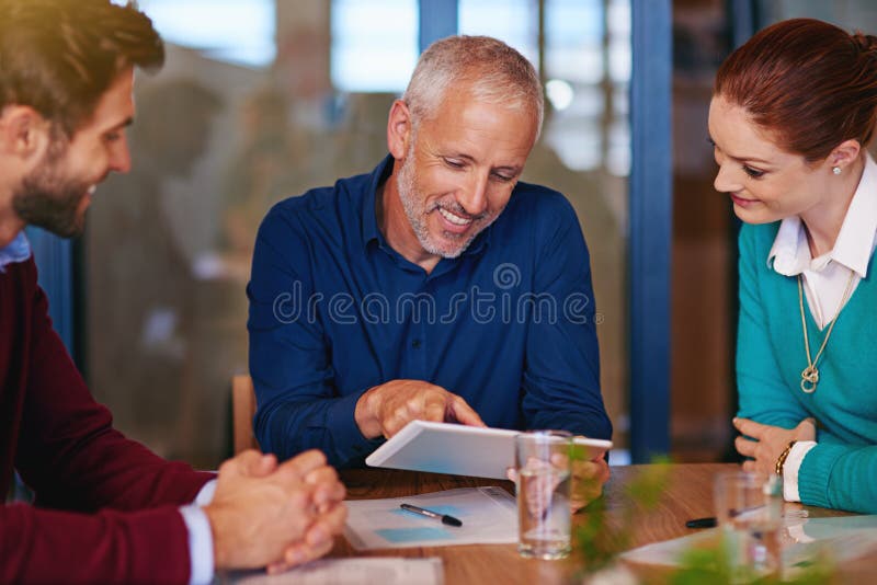 Theyre always Hard at Work. Businesspeople Using a Digital Tablet in a ...