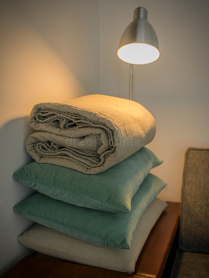 Thick Blanket Folded on Top of Stacked Pillows beside a Sofa. Stock ...