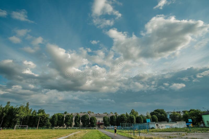 Thick Cloudy Blue Sky Above the School Yard and Shady Trees Green Stock ...