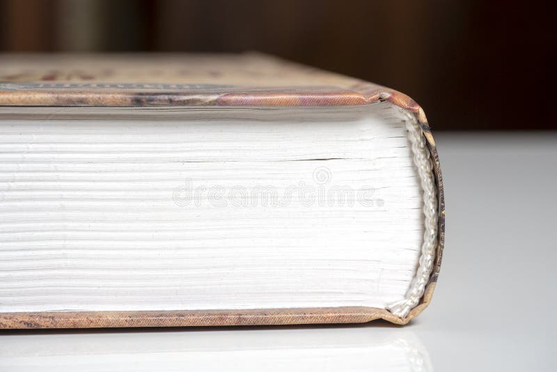 A Thick and Heavy Closed Book Lies on a White Surface in the House. the ...