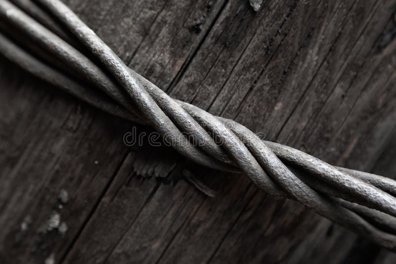 Thick Rusty Wire Twisted Around a Pillar. Old Twisted Wire on a Wooden ...
