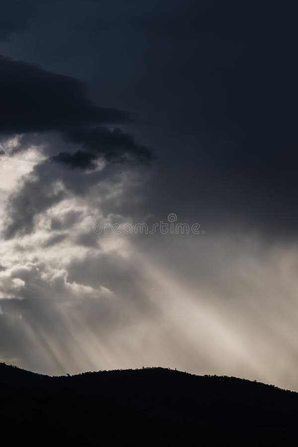 Thick Stormy Clouds Over the Mountains with Intense Sun Rays Peaking ...