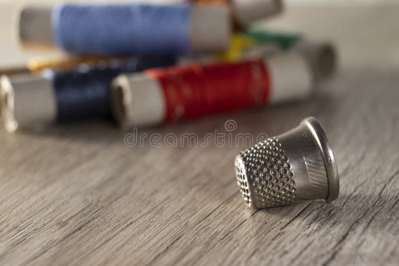 Thimble on a Background of Threads on a Wooden Background. Colored ...
