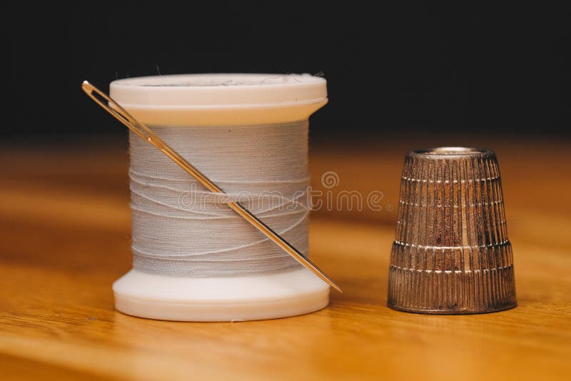 Thimble and Thread with Needle on Table Stock Photo - Image of ...