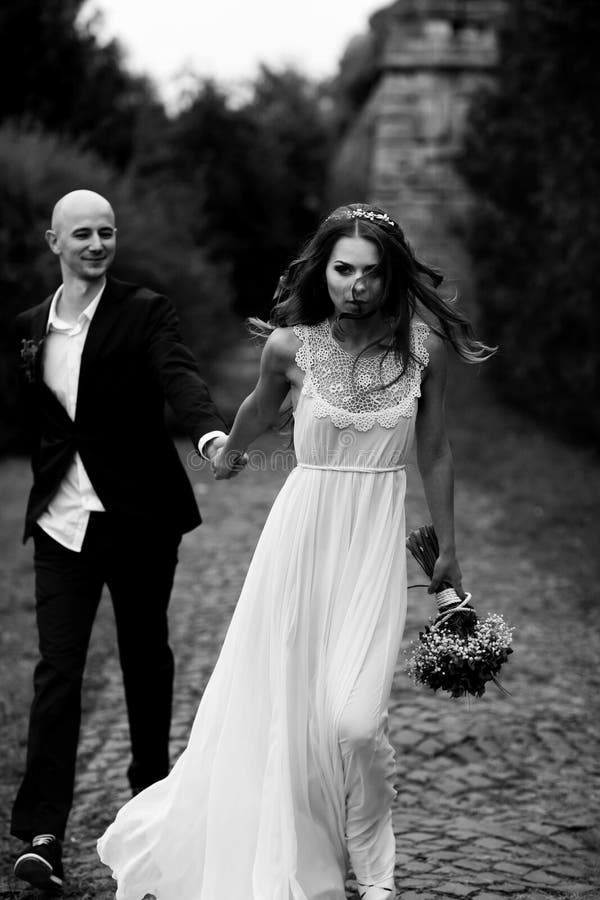 Thin Bride Looks Gorgeous Walking with Groom Along the Path Stock Photo ...