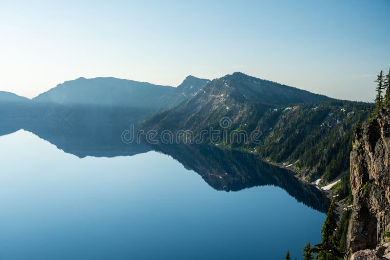 Thin Haze Hangs Over the Cliffs and Mirror Still Water of Crater Lake ...