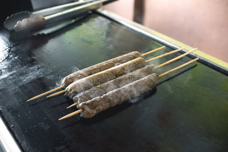 Thin and Long Beef Kebab on Sticks Cooked on a Large Flat Gas Griddle ...