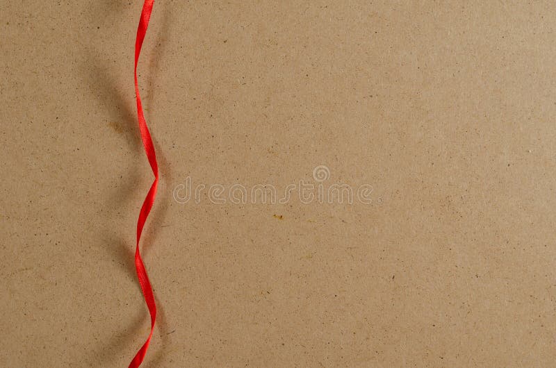 A Thin Red Ribbon Vertically Against the Brown Background. Stock Photo ...