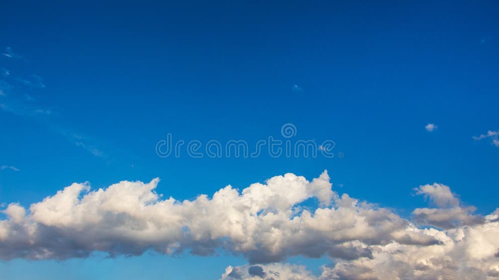 A Thin Strip of White Fluffy Clouds Below the Blue Sky_ Stock Image ...