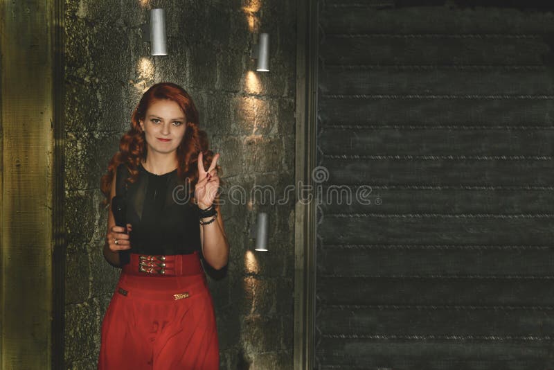 Red Haired Event Host with a Microphone in a Room with Lanterns and a ...
