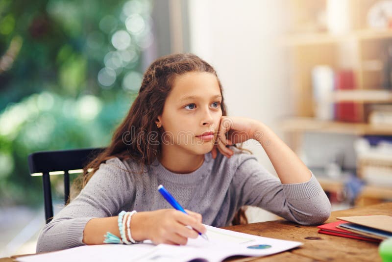 Thinking about the Answer. a Young Girl Doing Homework Inside. Stock ...