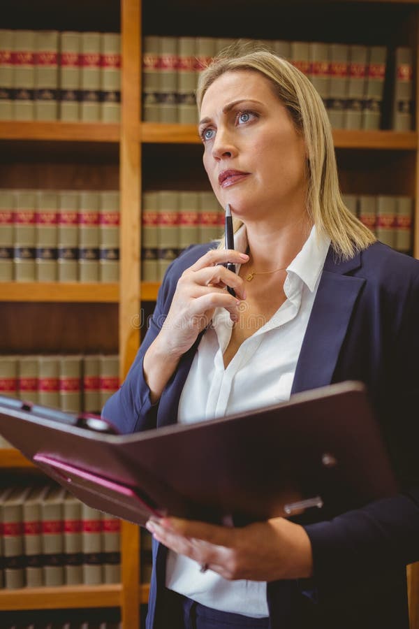 Thinking Female Librarian Holding Textbook Stock Photo - Image of book ...