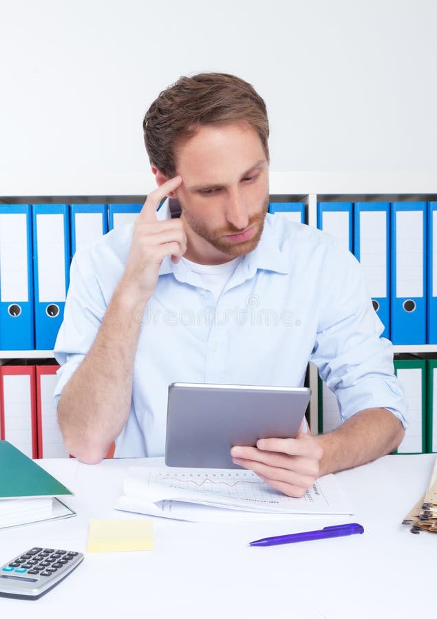 Thinking German Businessman with Tablet Computer at Office Stock Image ...