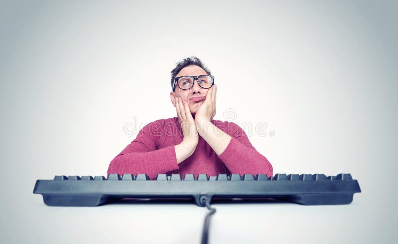 Thinking Man in Glasses Behind a Keyboard in Front of a Computer ...