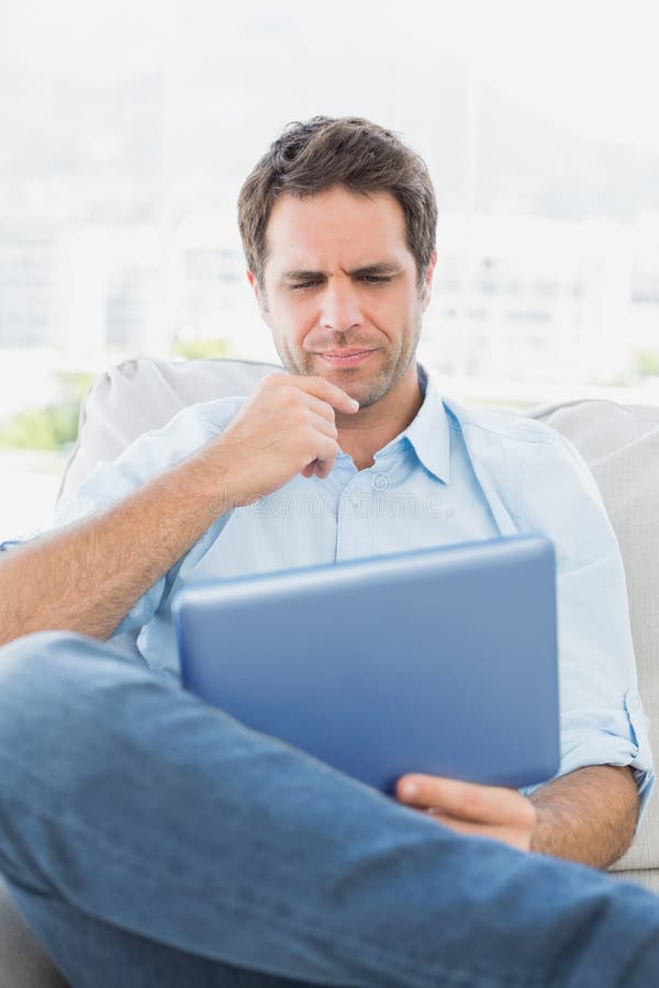Thinking Man Sitting on the Couch Using His Tablet Stock Photo - Image ...