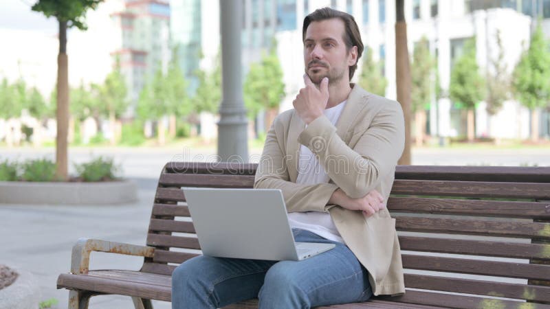 Thinking Young Man Using Laptop while Sitting on Bench Stock Photo ...
